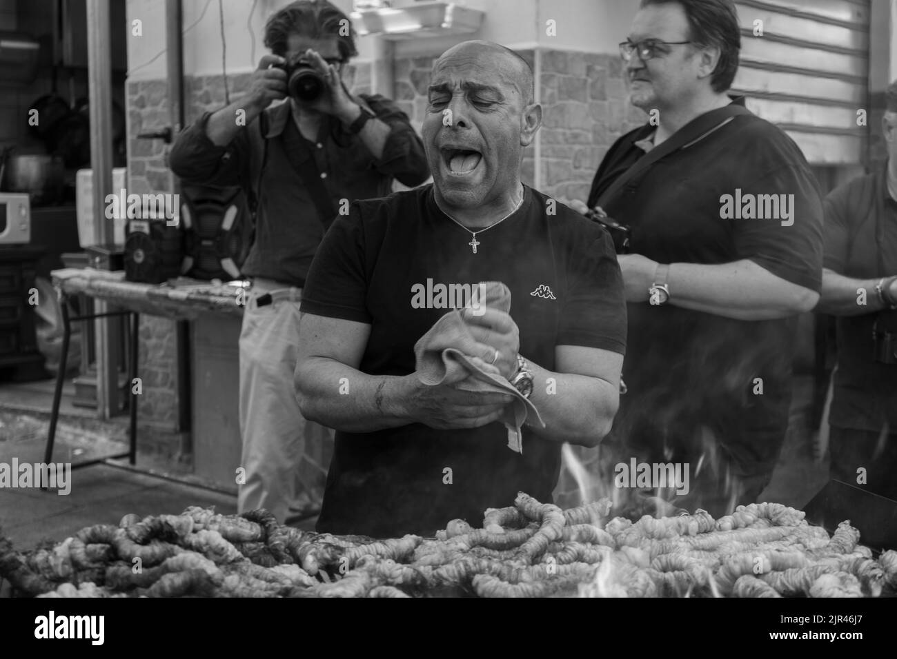 A grayscale of a male grilling local specials in Ballaro Market Stock ...