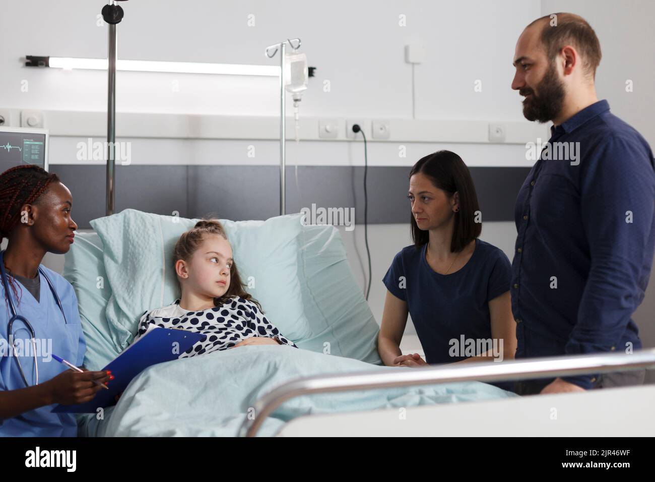 Children healthcare facility staff talking with parents about sick ...