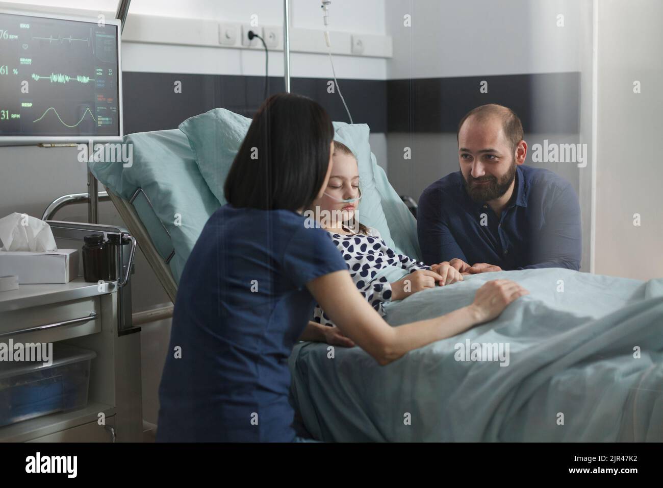 Loving family comforting under treatment sleeping ill kid in hospital ...
