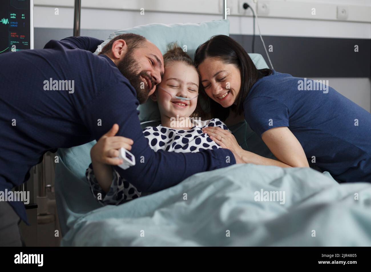 Happy sick little girl hugged by joyful smiling parents in hospital ...