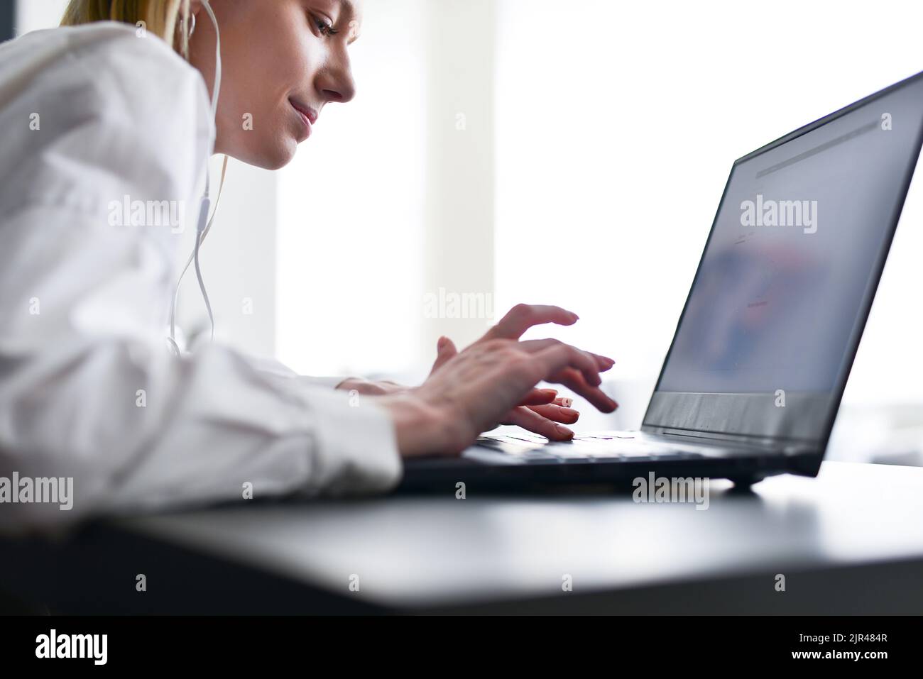 Woman typing on laptop keyboard. Focus on face Stock Photo - Alamy
