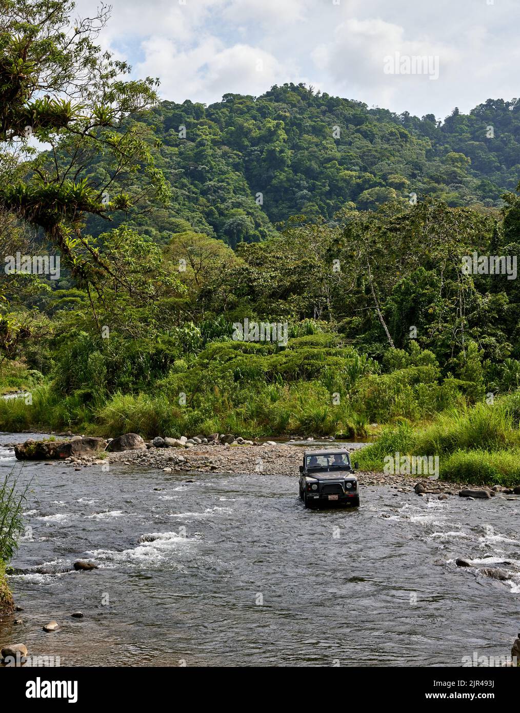 An off-road truck crossing a river against the forest landscape in La ...
