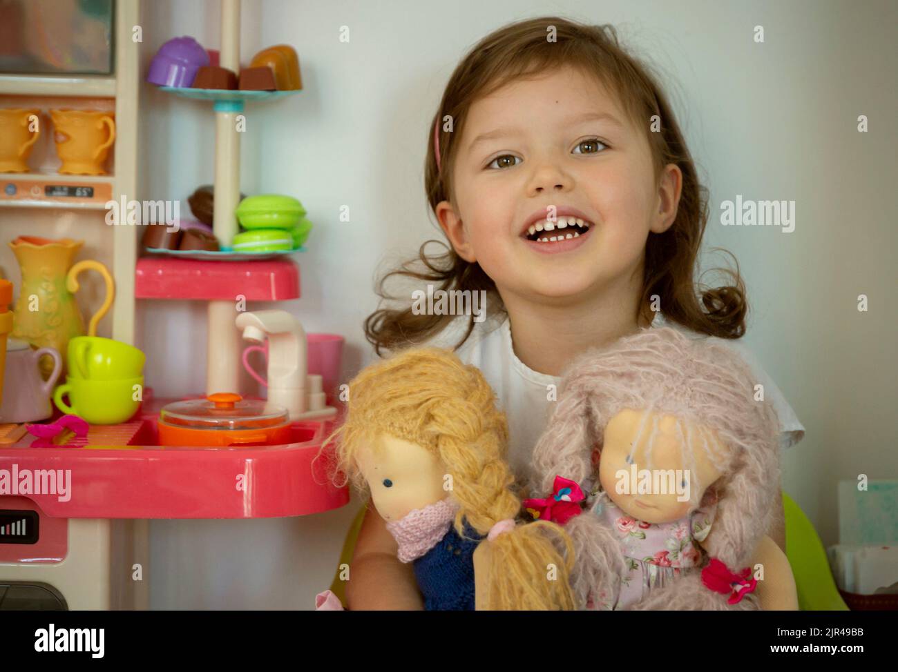 Cute little girl playing with her dolls Stock Photo - Alamy