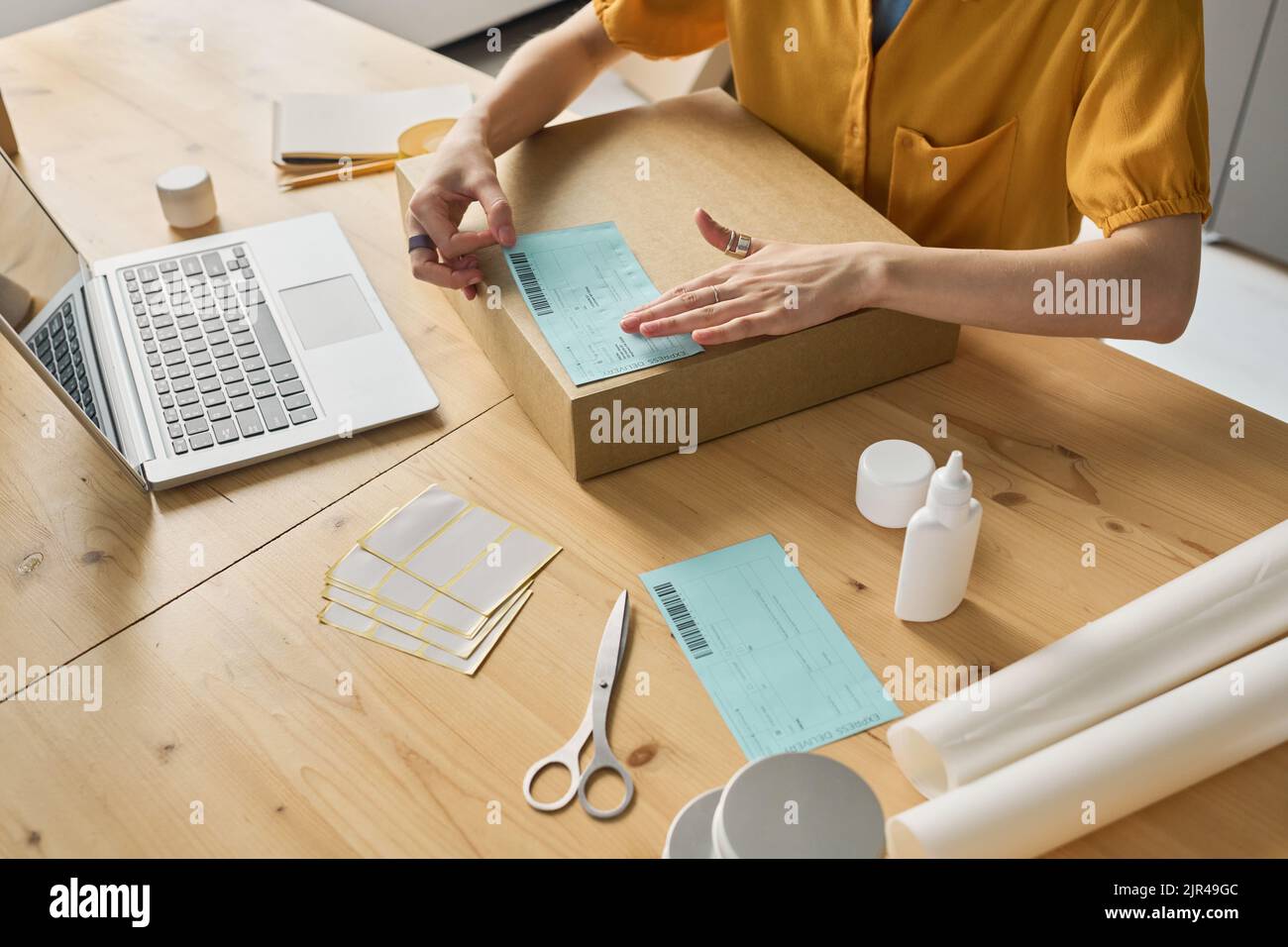 High angle view of worker sticking receipt on cardboard box for ...