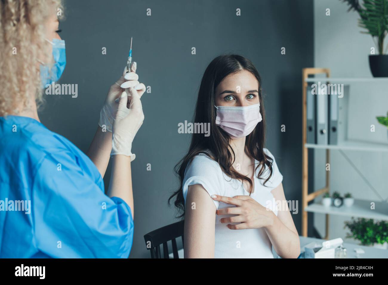 Female doctor preparing coronavirus vaccine for woman patient at ...