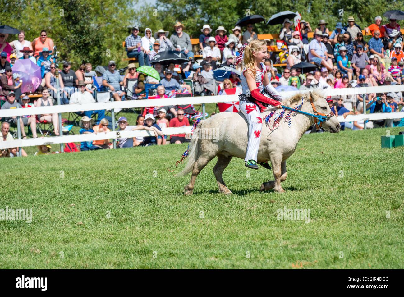A young girl rides a pony in front of onlookers at the RCMP Musical ...