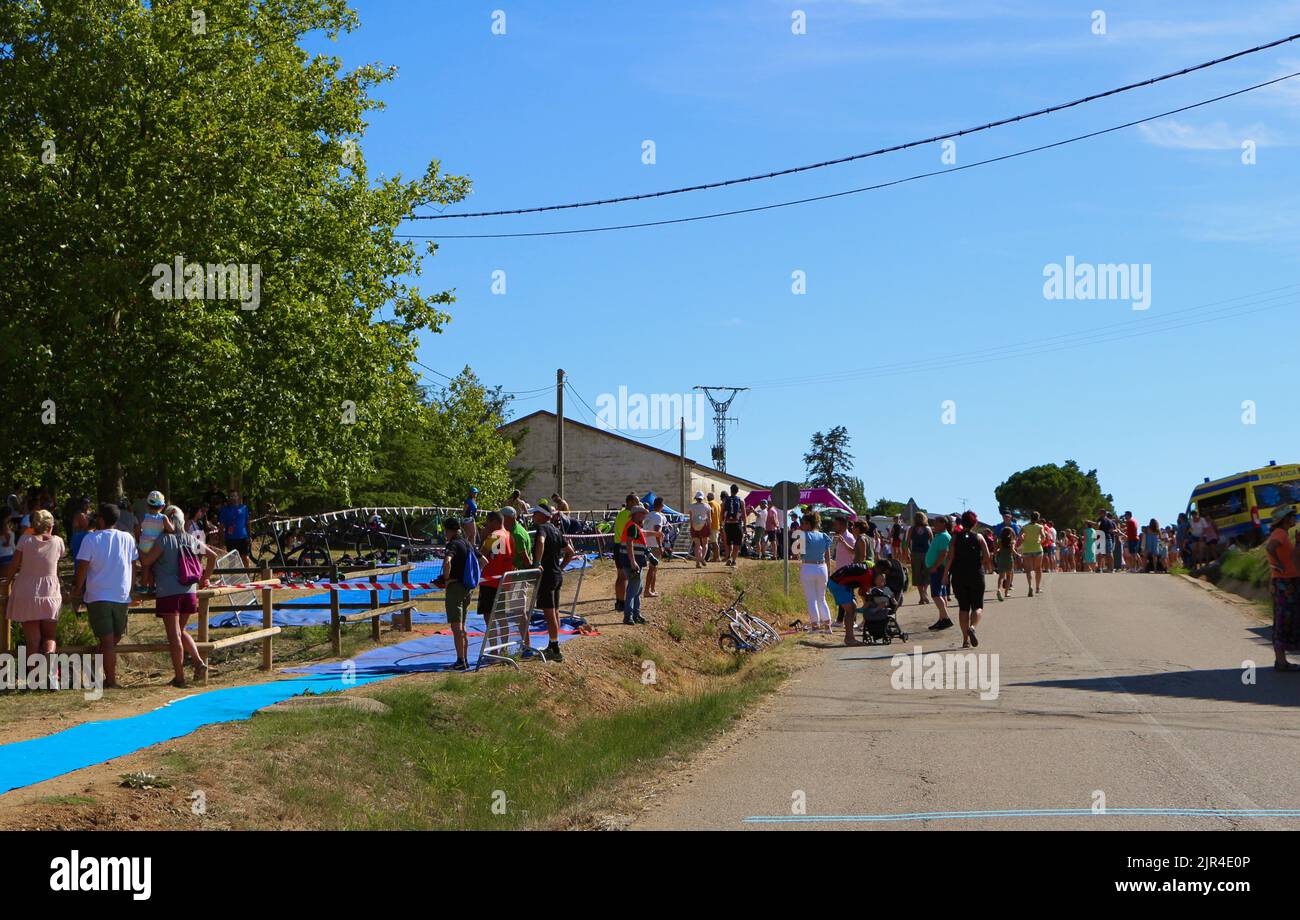 Public waiting for competitors to arrive to take their bikes for the cycling stage of the ...