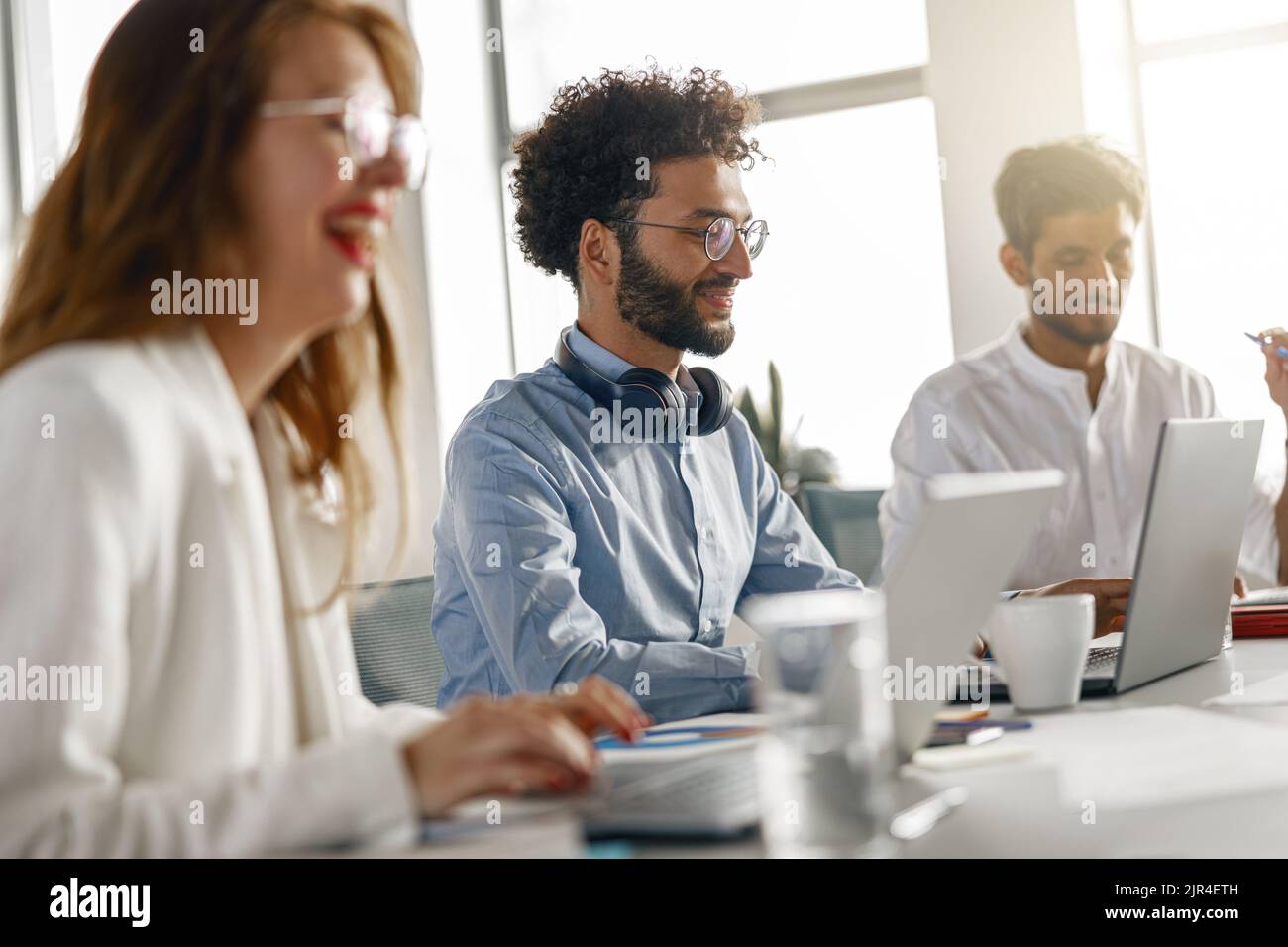 Group of young diverse coworkers analyzing sales report while working ...