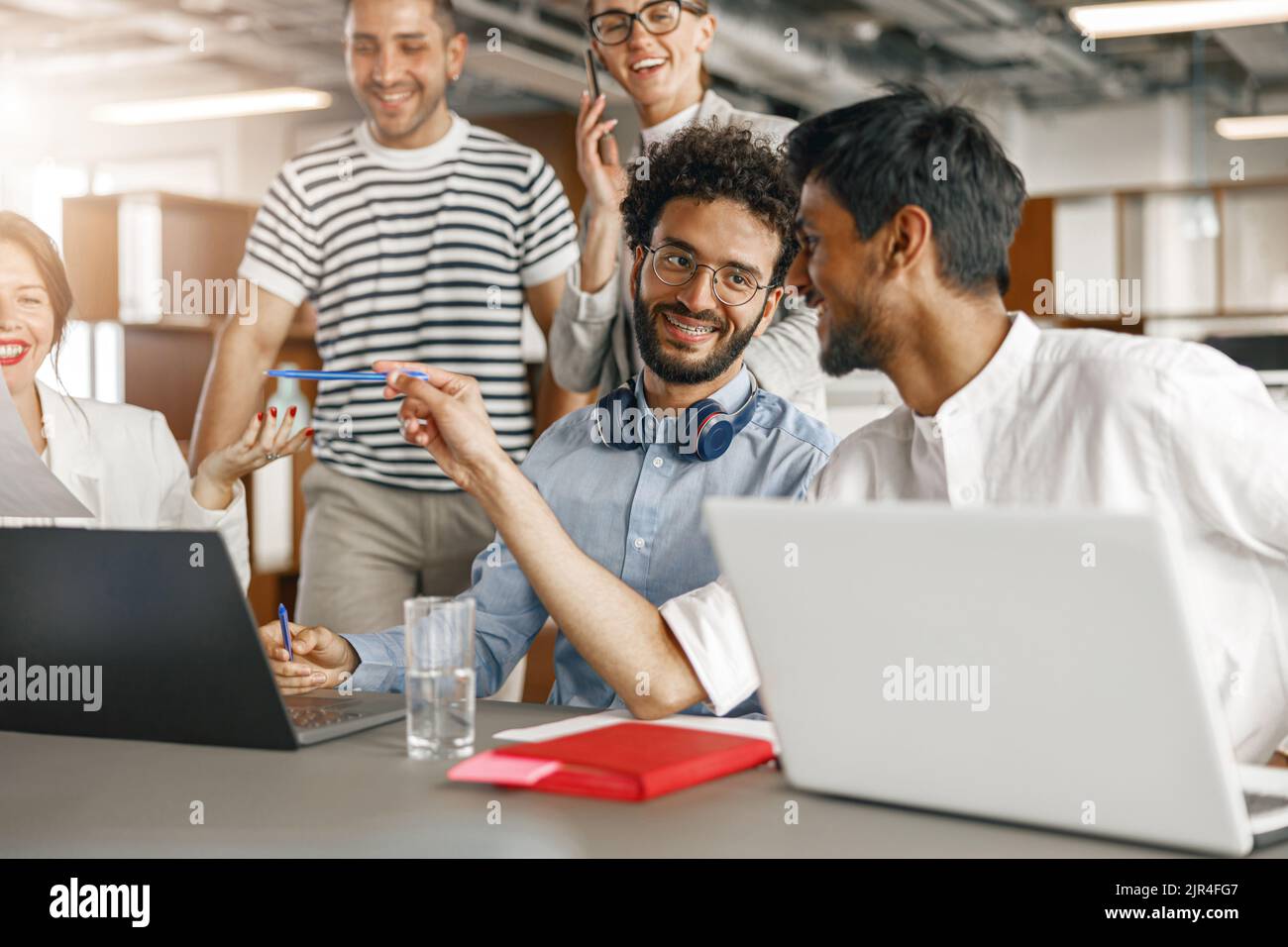 Diverse group of colleagues enjoying working together in an office ...