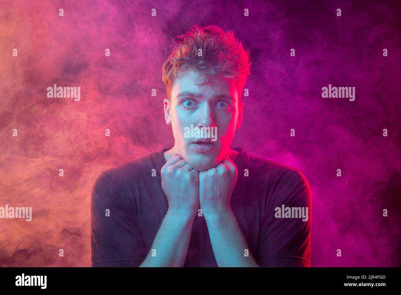 Smoke enveloped young man. Model looking at camera isolated over ...