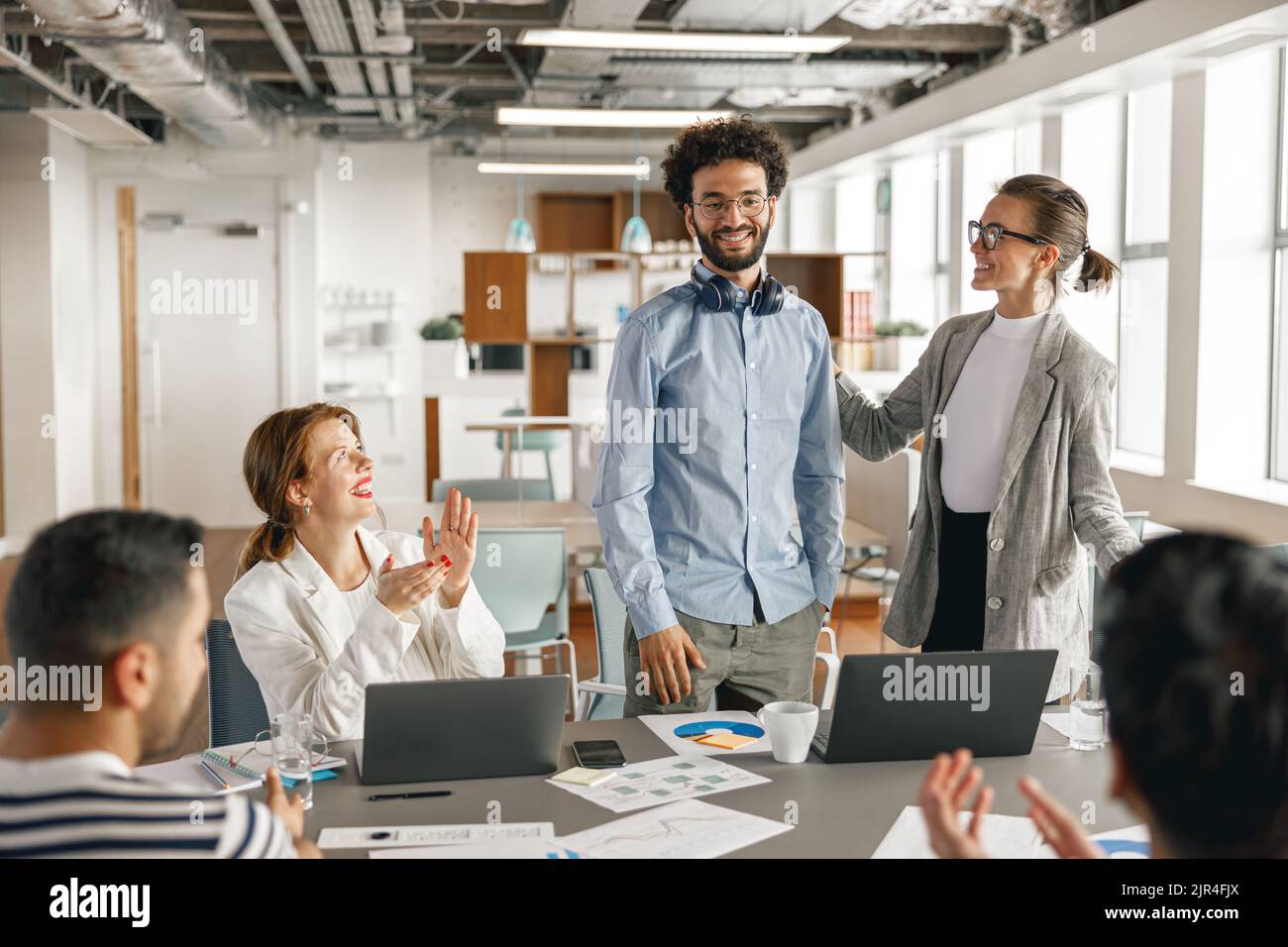 Happy coworkers cooperating and working together at office meeting ...
