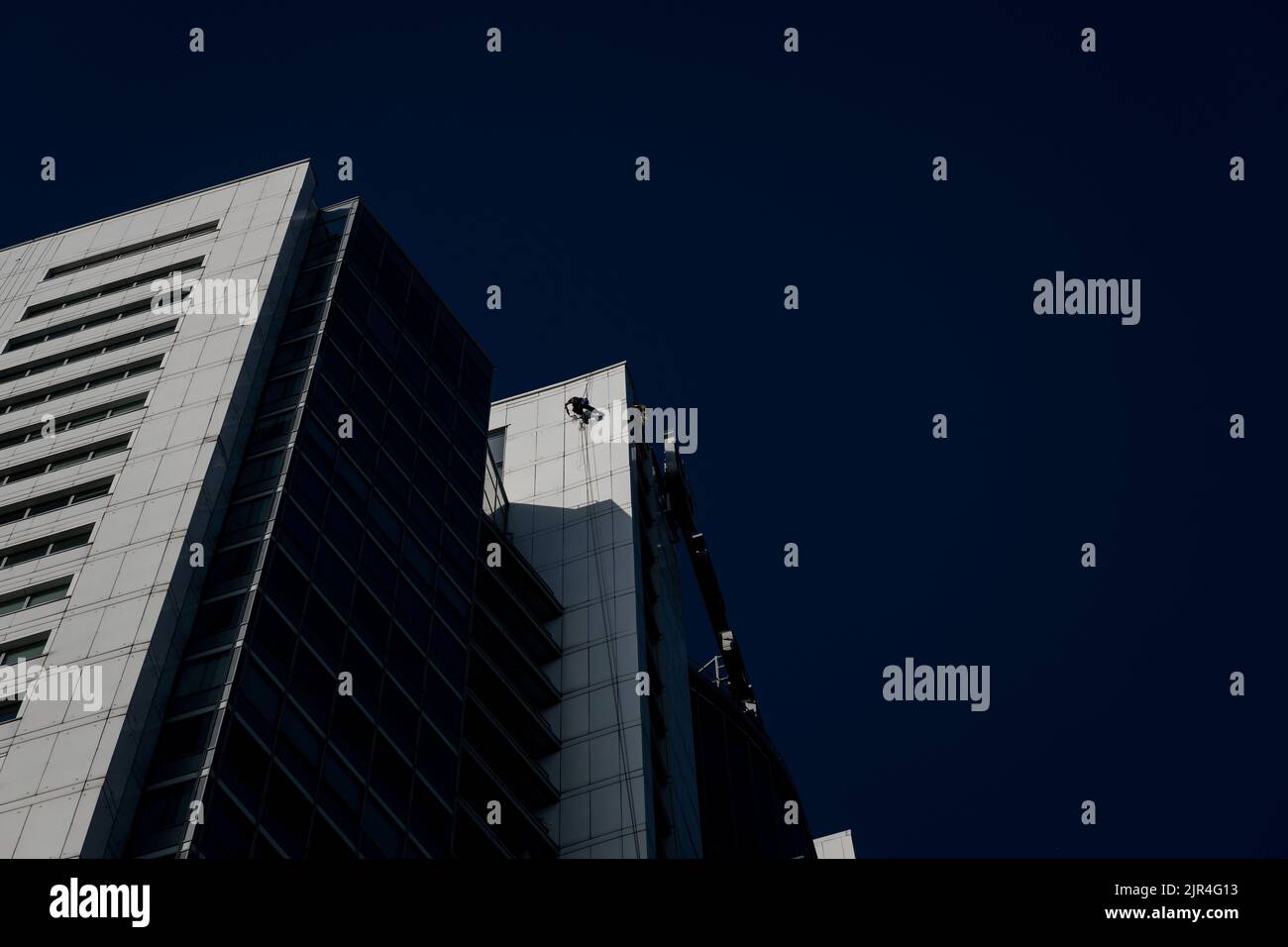 Industrial climber in helmet and uniform over sky background. Extreme ...