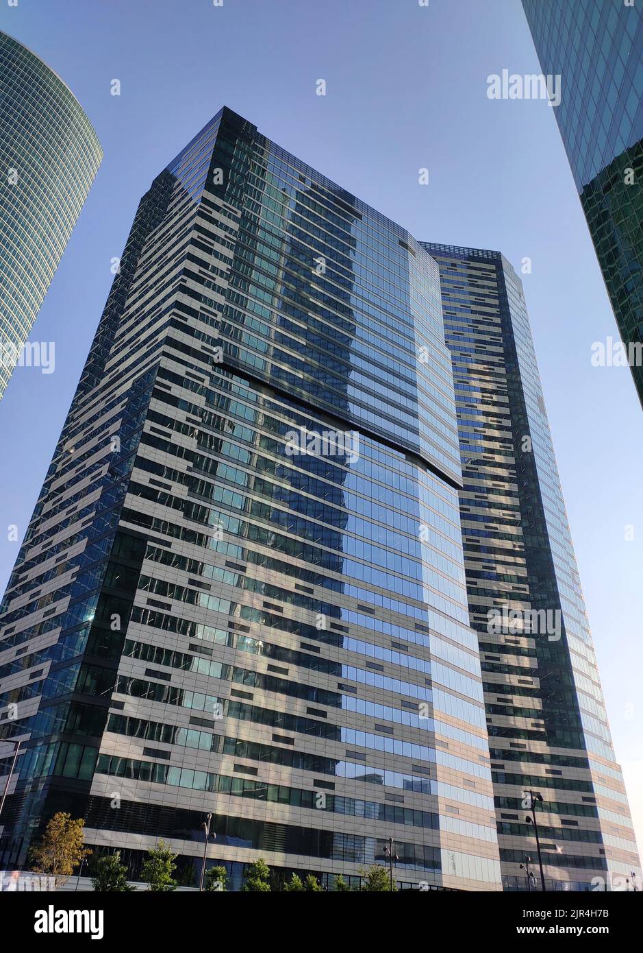 Bottom view on skyscraper and blue sky. Modern office building in the ...