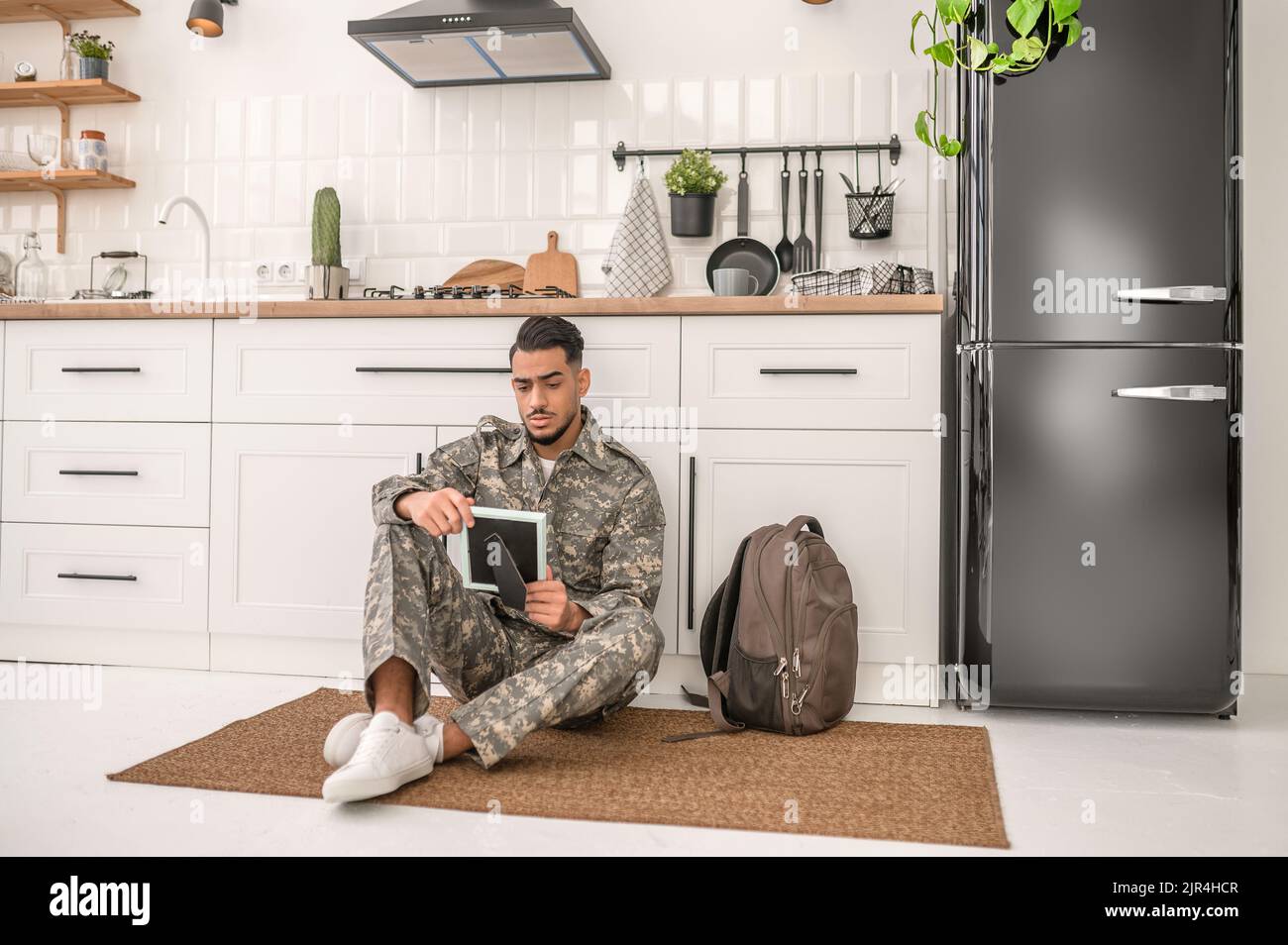 Sad army soldier gazing at the photo in his hands Stock Photo - Alamy
