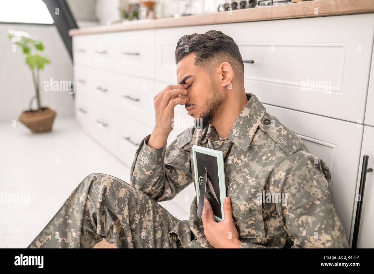 Sad army soldier holding the framed photograph in the hand Stock Photo ...