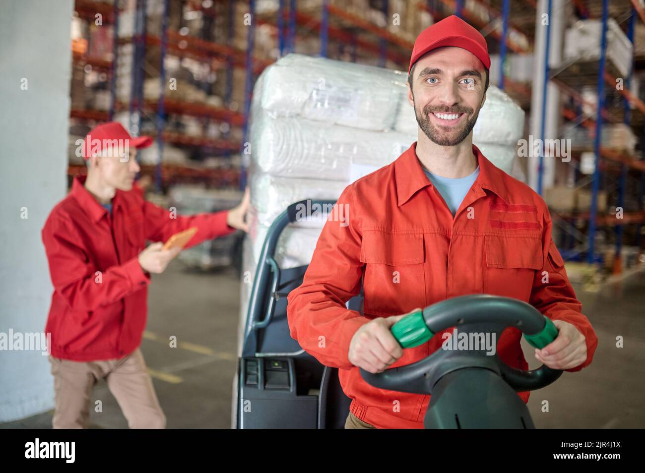 Two experienced workers moving goods around the warehouse Stock Photo ...