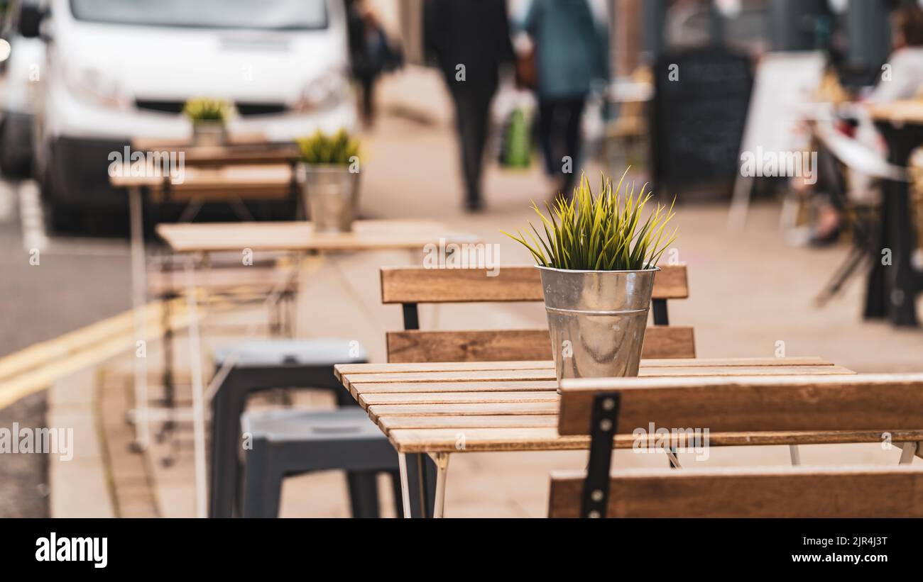 Outdoor Café Table with Potted Plant on Pavement Stock Photo - Alamy