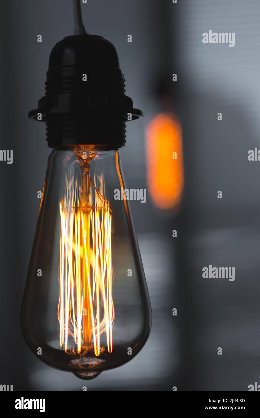 A classic Edison light bulb on dark background with space for text ...