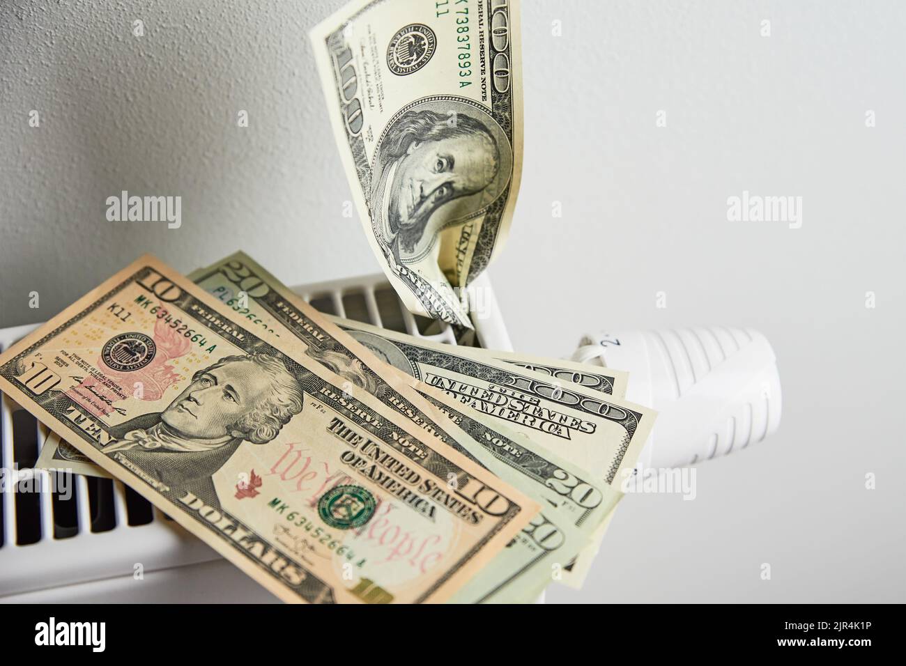 Heating radiator with dollar bills closeup, Energy crisis concept ...