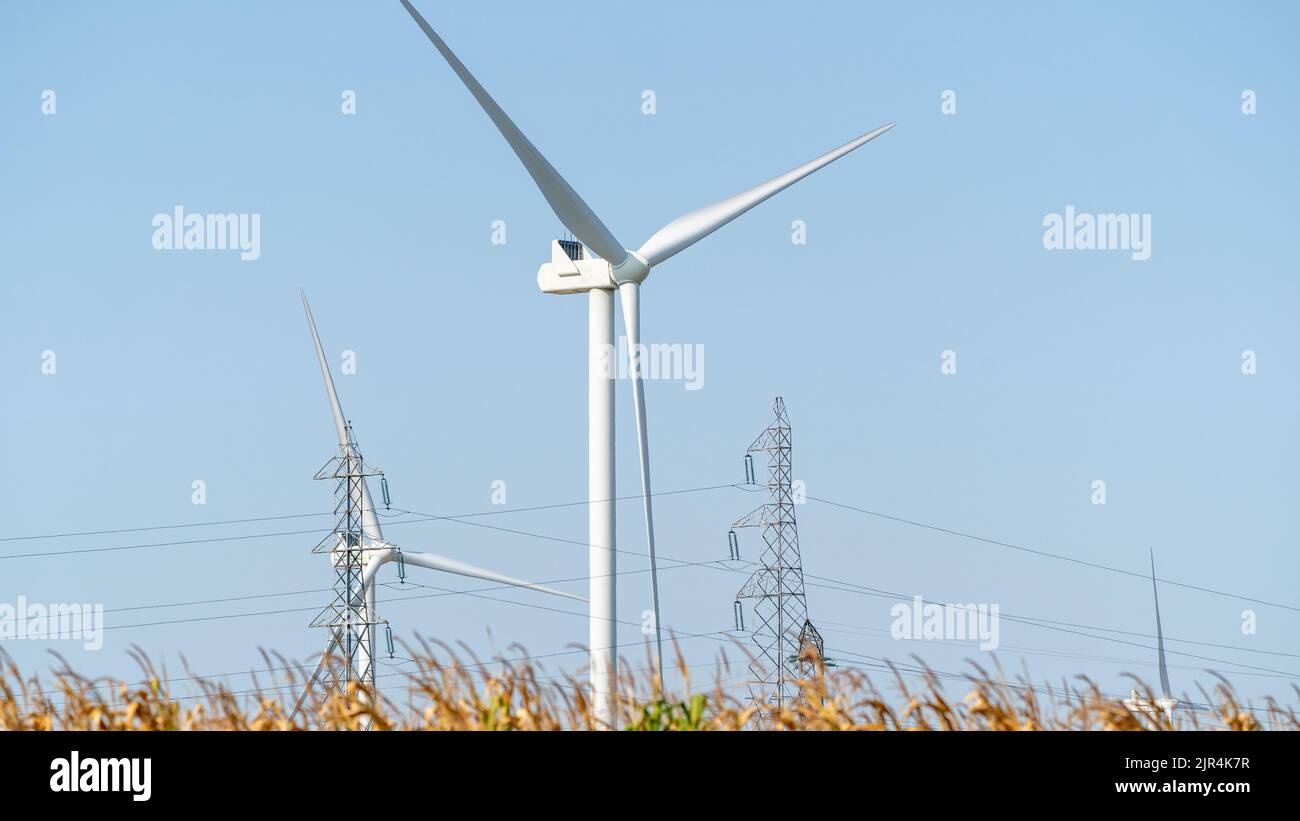 Wind turbine and pylons on a blue sky Stock Photo - Alamy