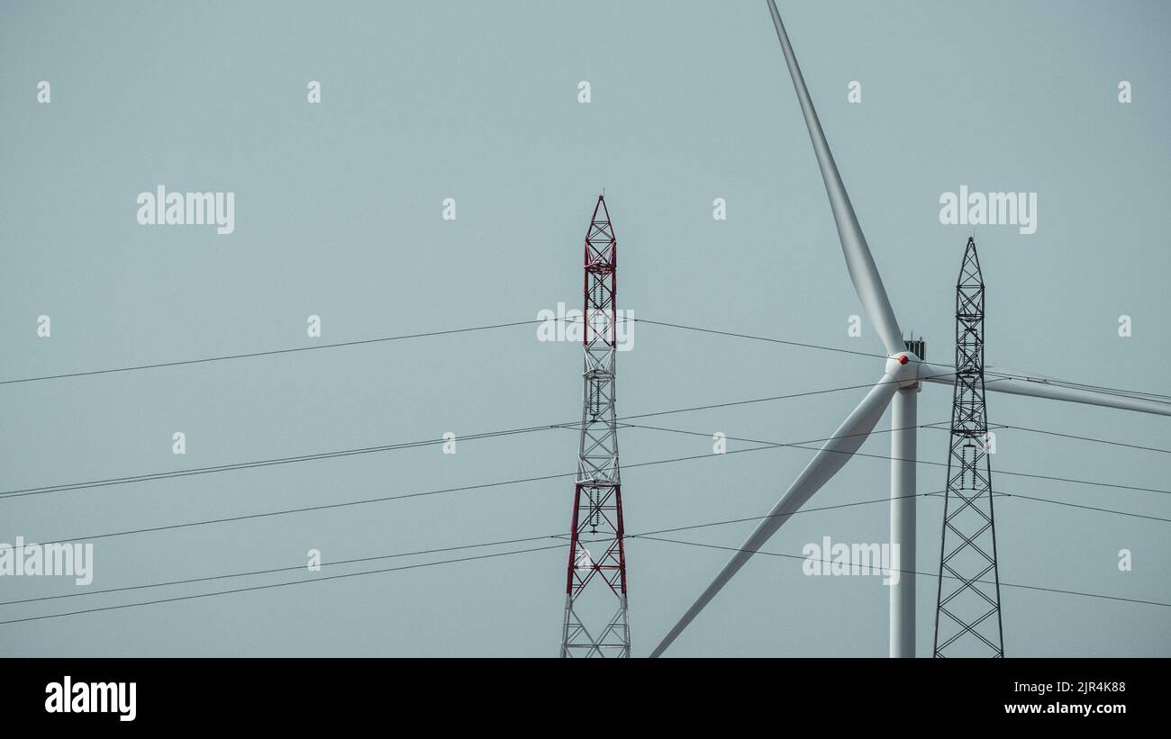 Wind turbine and pylons on a blue sky Stock Photo - Alamy