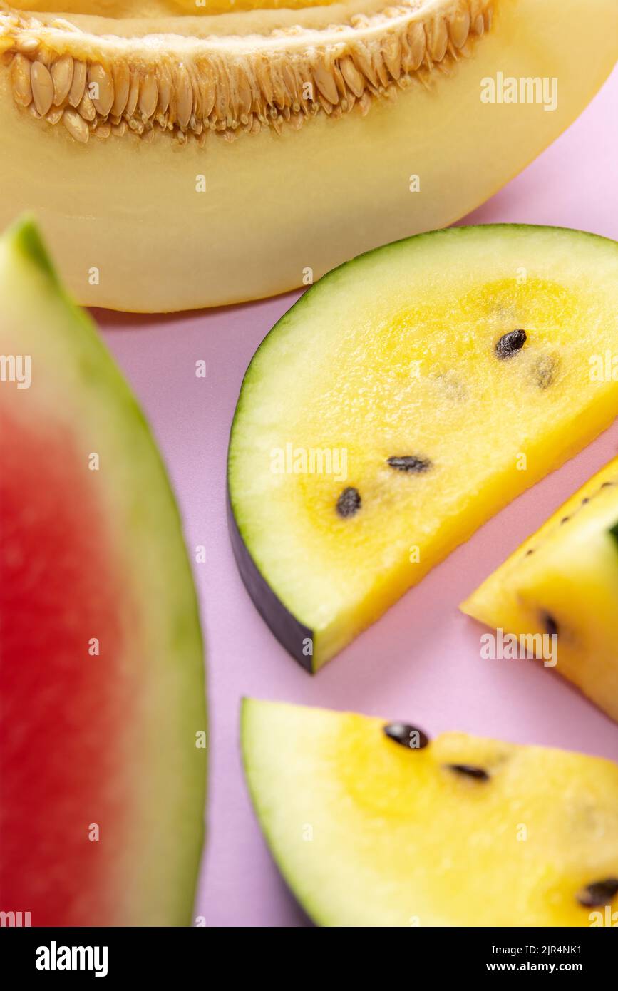 Top view of ripe juicy red and yellow watermelon slices over colorful ...