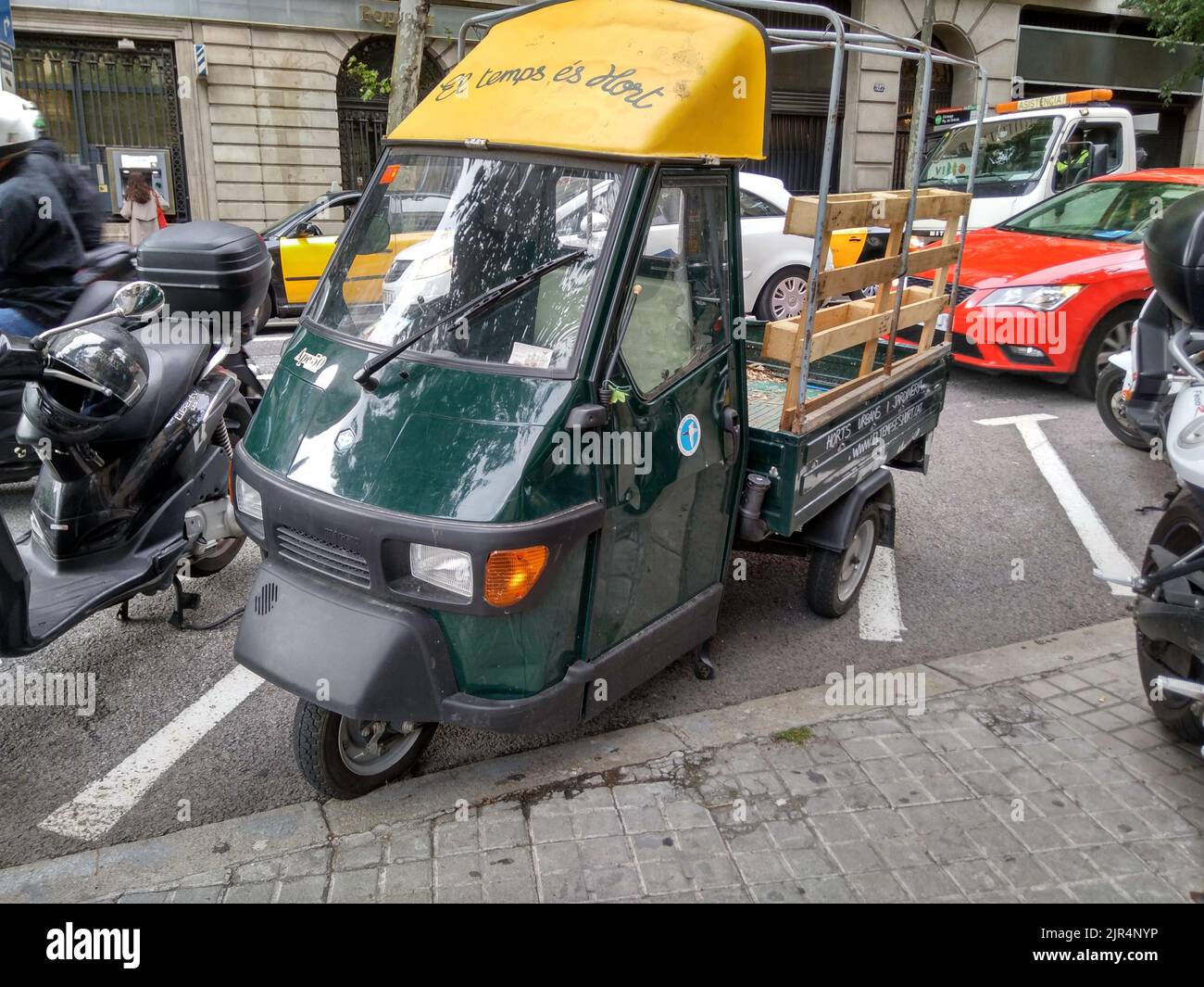 A classic green Piaggio APE three-wheeler parked on the street Stock ...