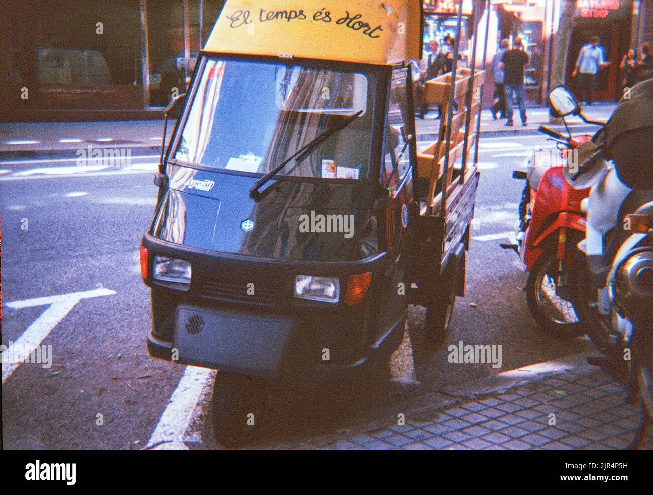 A classic green Piaggio APE three-wheeler parked on the street Stock ...