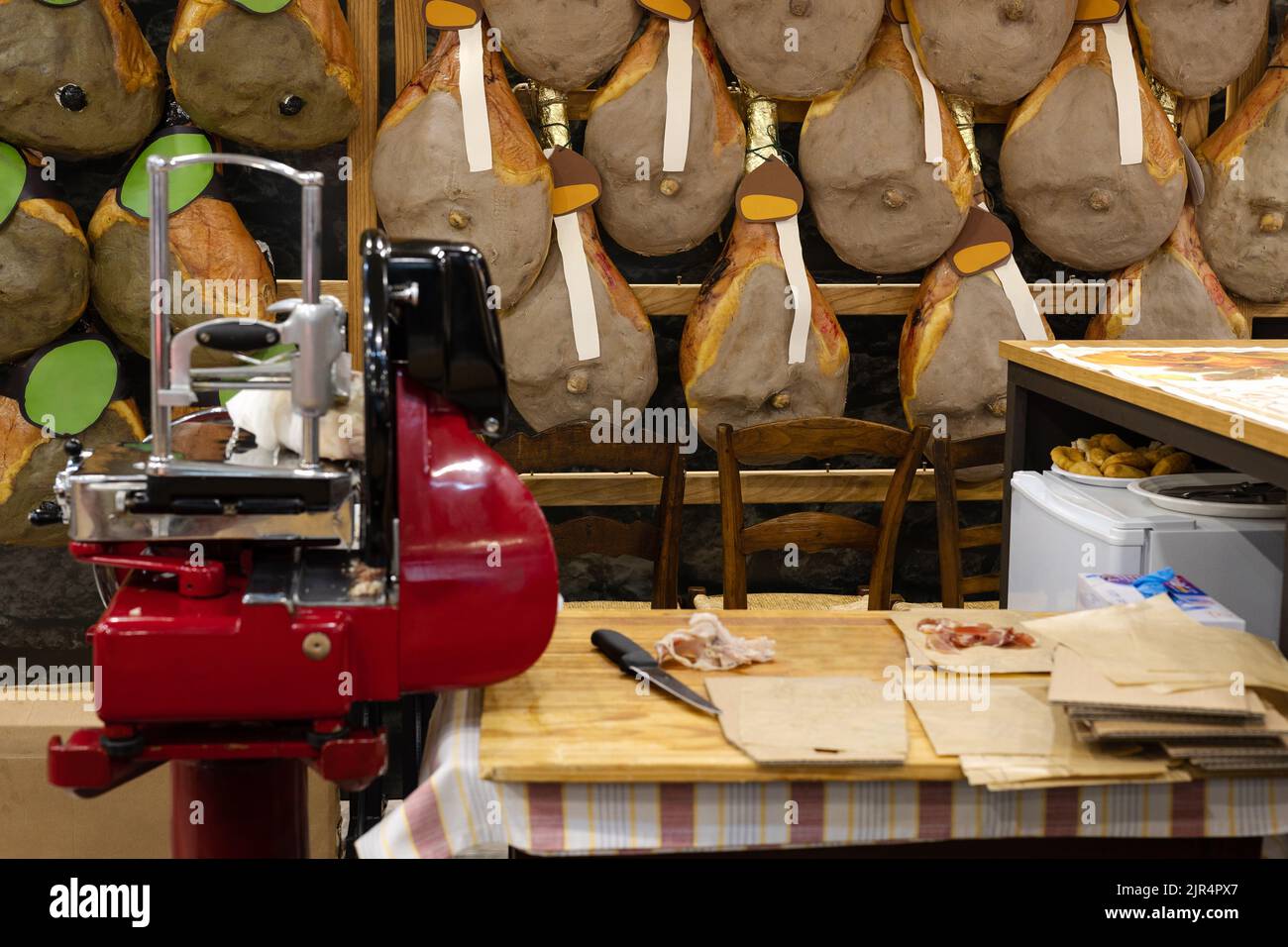 Red Slicer and Group of Whole Raw Hams hung on a Wall Stock Photo - Alamy