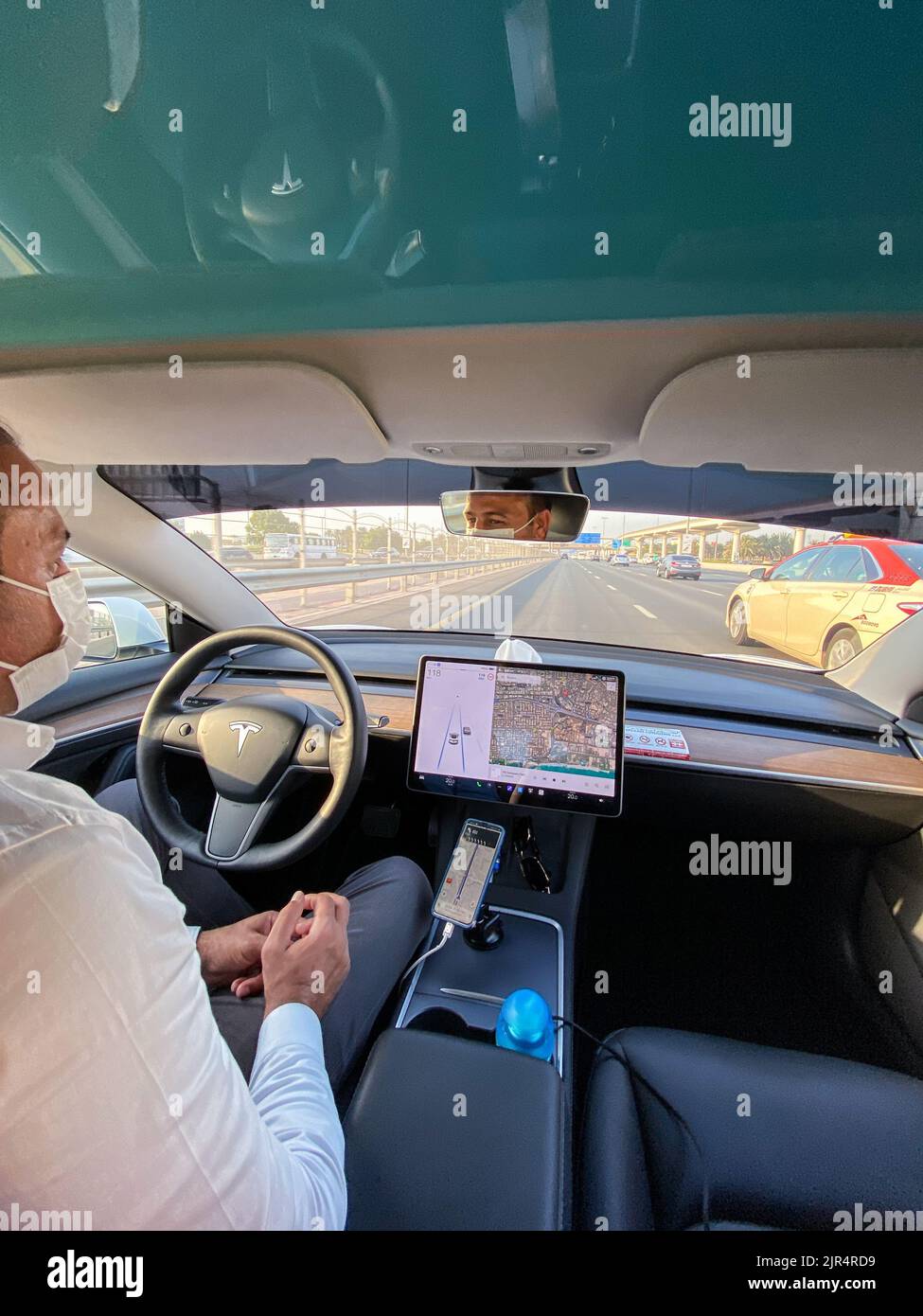 An Uber driver driving hands free in his Tesla in Abu Dhabi, UAE Stock ...