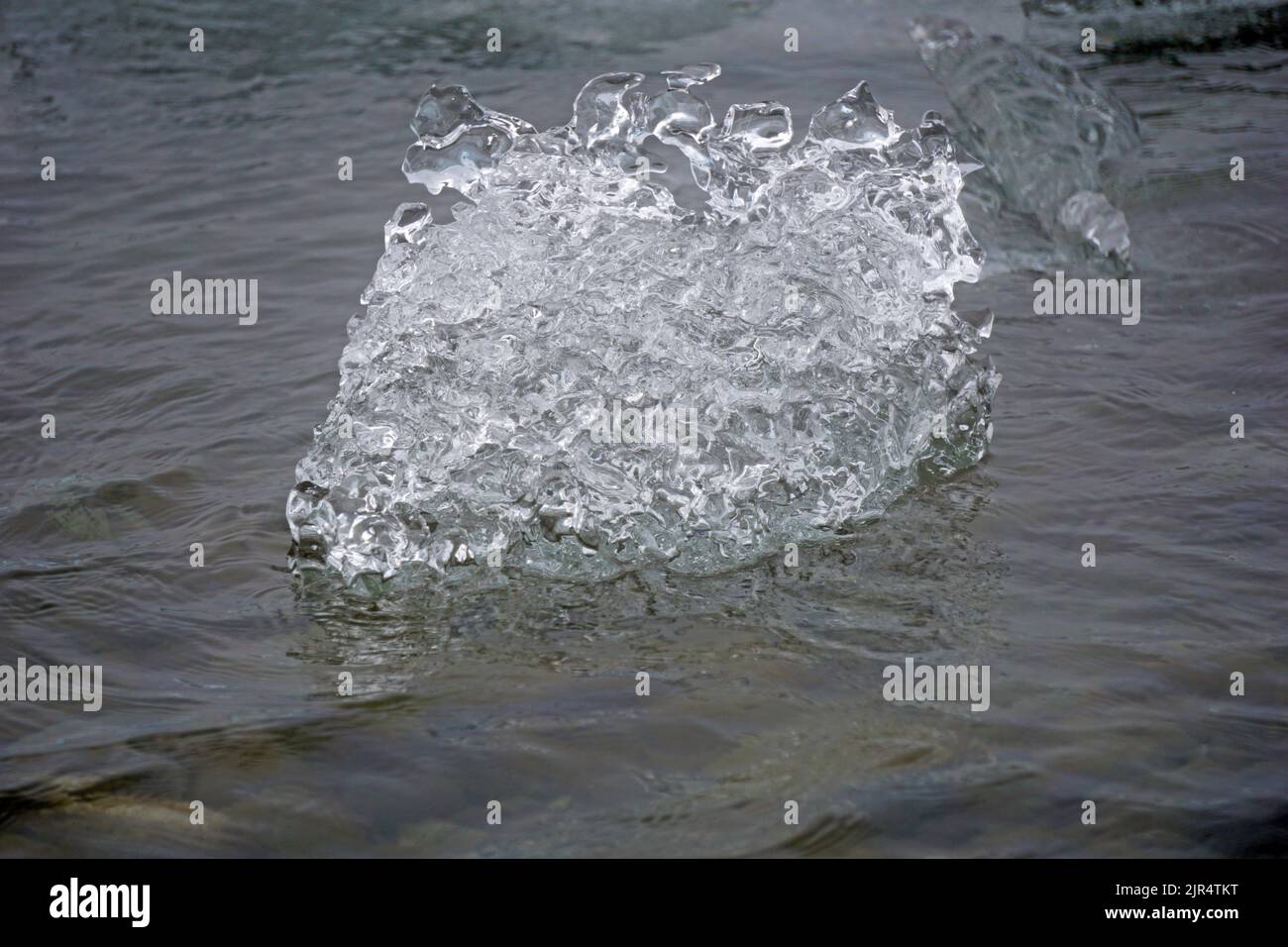 Block of ice melting in water Stock Photo - Alamy