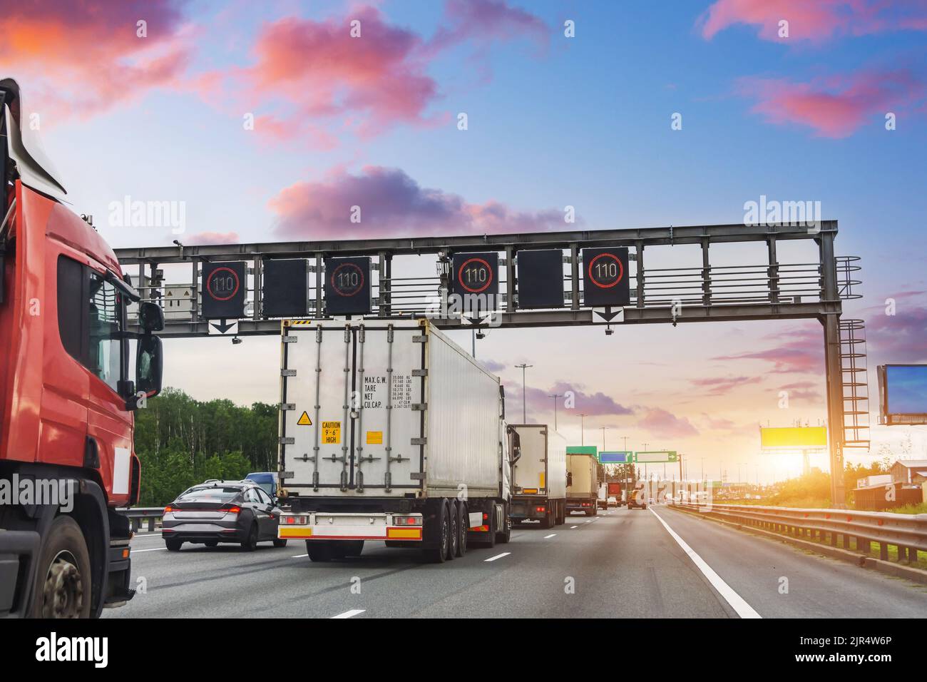 Dense traffic of cargo trucks on a high-speed road at a speed of 110 ...