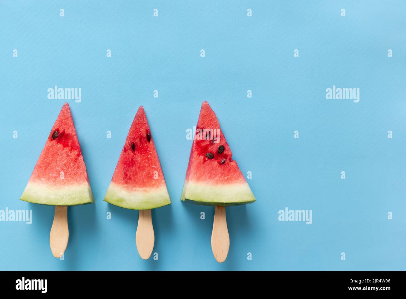 Fruit ice cream. Summer watermelon slice popsicles on blue background ...