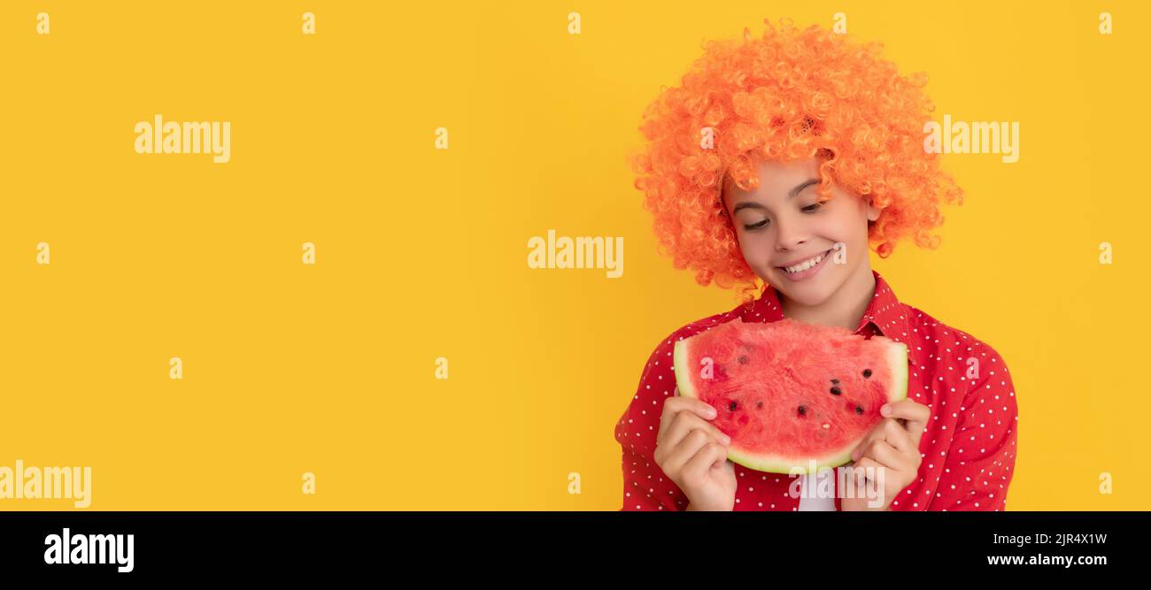 smiling teen girl in fancy orange hair wig hold fresh ripe watermelon ...