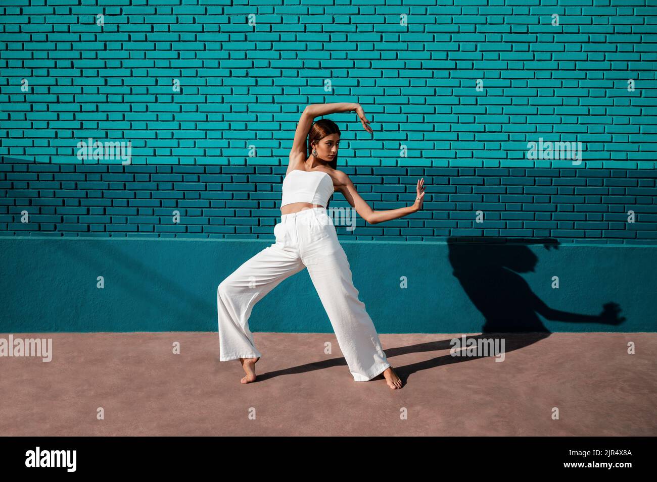 A caucasian woman dancing urban dance with daylight and a green ...
