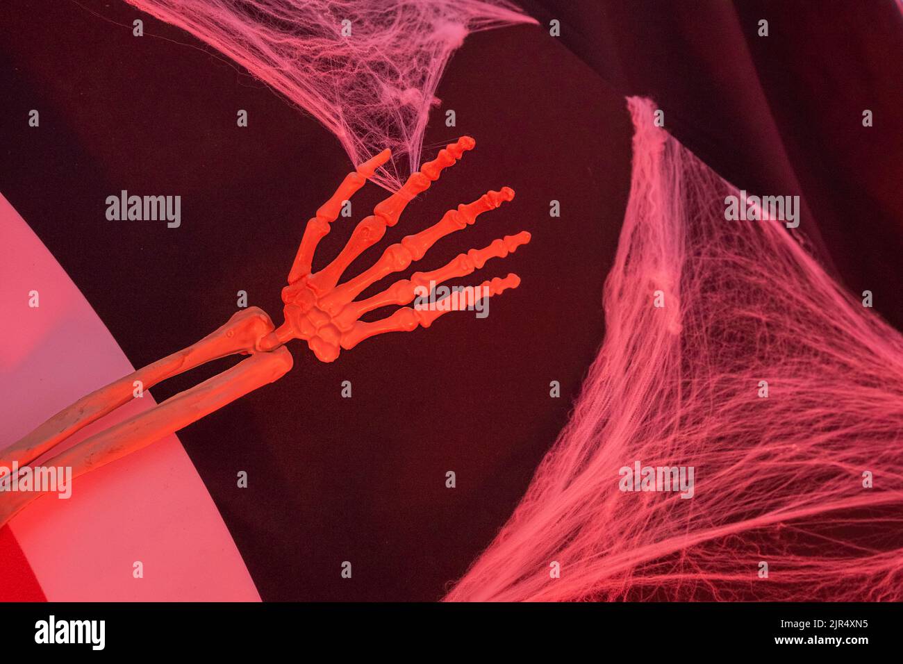 Hand skeleton and webs on red Neon. Halloween decor Stock Photo - Alamy