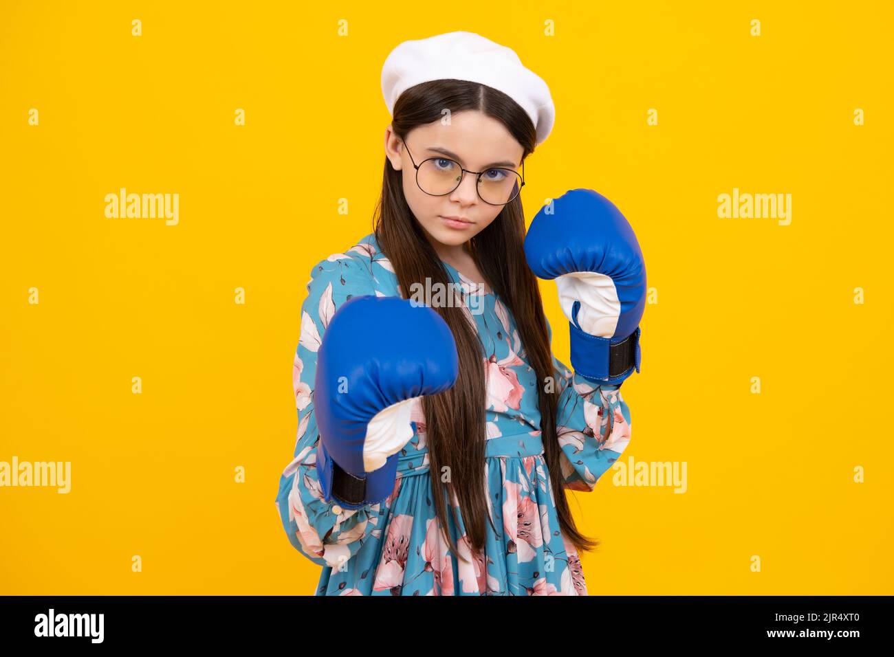 Portrait of a cute teenage boxer girl on yellow isolated background ...