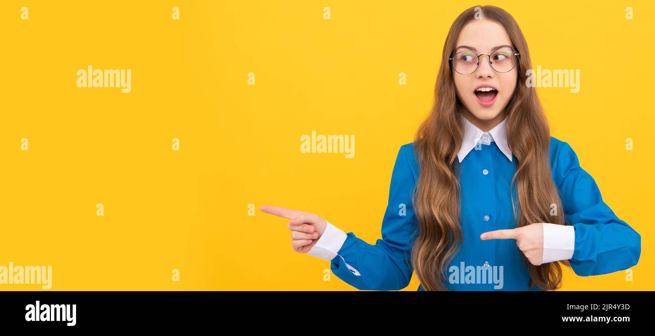 Surprised kid point fingers yellow background. Pointing for advertising ...