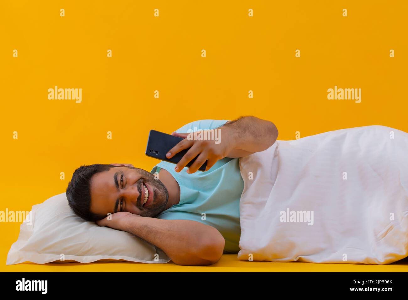 Portrait of a young man talking on video call while lying down Stock ...