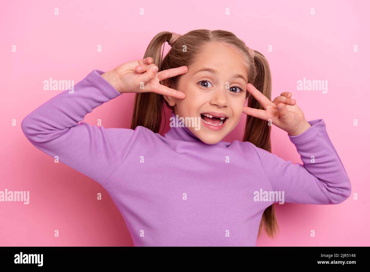 Photo of young little charming girl laughing showing v sign say hello ...