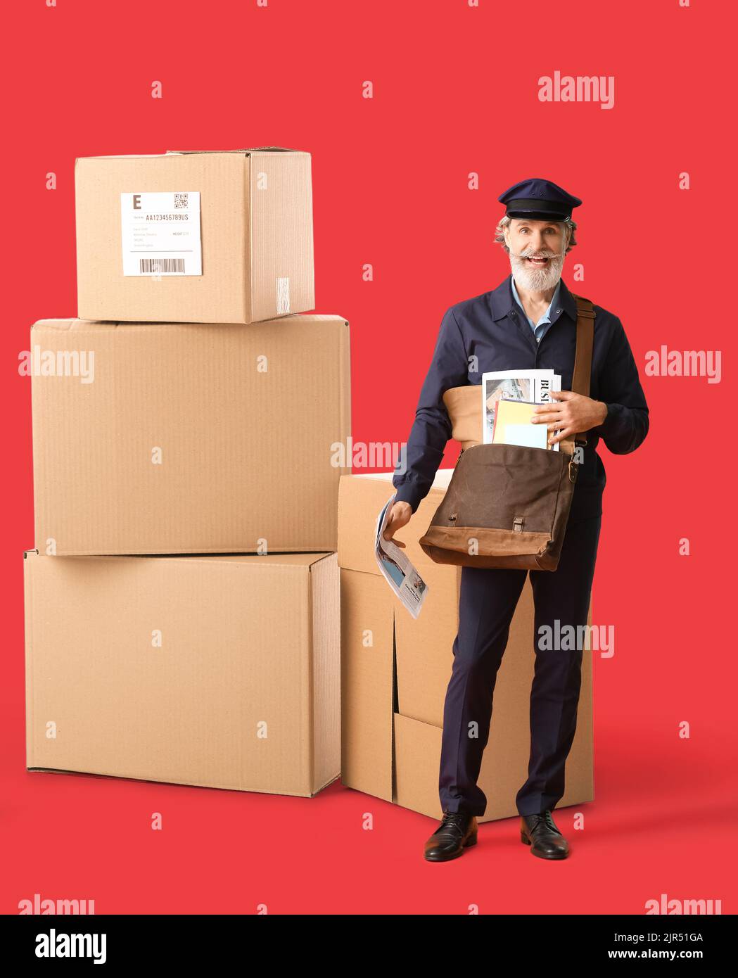 Handsome old postman and many big parcels on red background Stock Photo ...