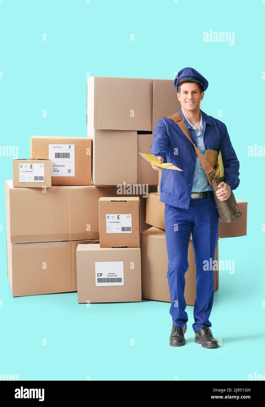 Handsome young postman and many big parcels on light blue background ...