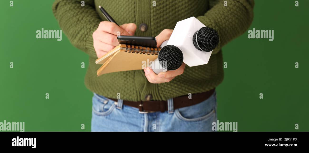 Male journalist with microphones on green background, closeup Stock ...