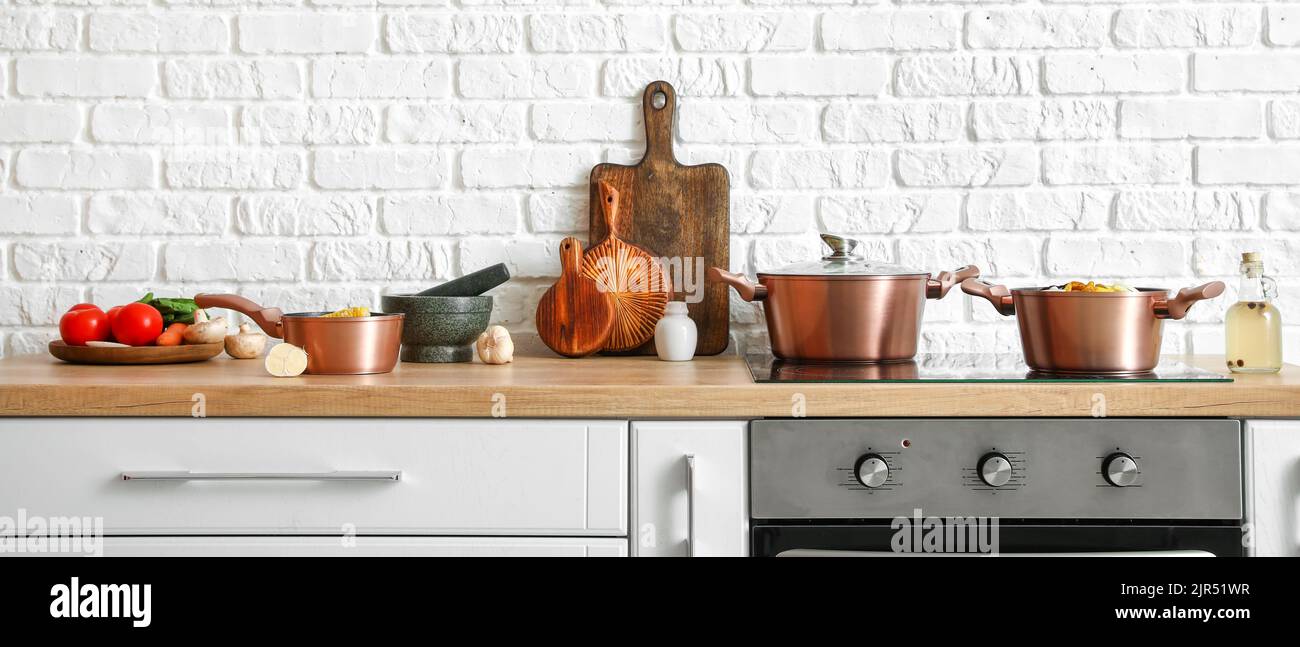 Modern electric stove with cookware, utensils and products in light ...