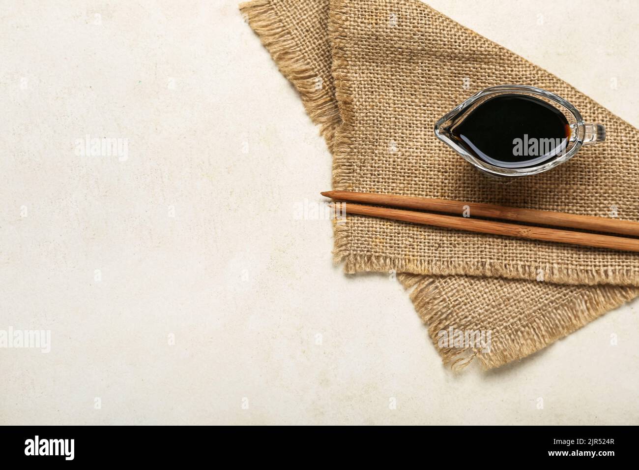 Gravy Boat Of Soy Sauce Chopsticks And Sack Cloth On White Background