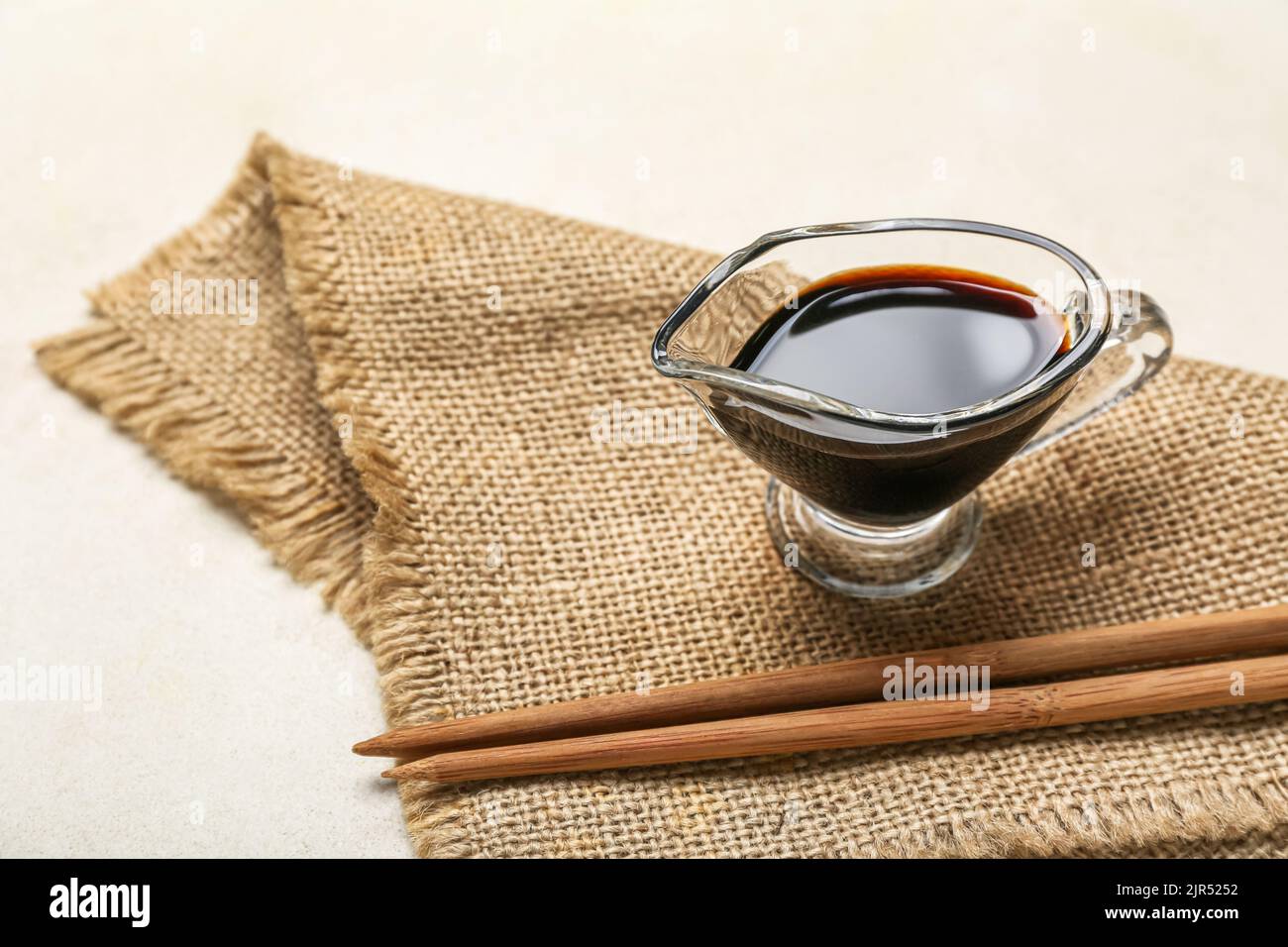 Gravy Boat Of Soy Sauce Chopsticks And Sack Cloth On White Background