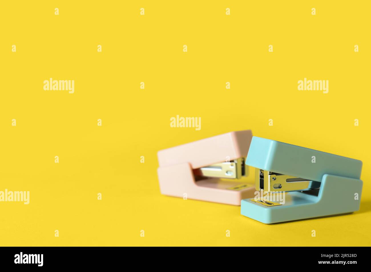 Colorful staplers on yellow background Stock Photo - Alamy