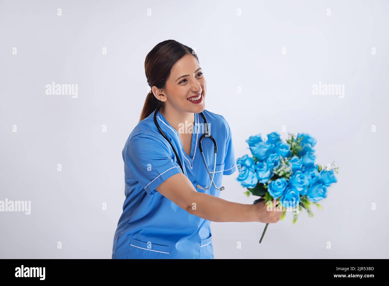 Portrait of smiling female nurse giving flower bouquet to patient Stock ...