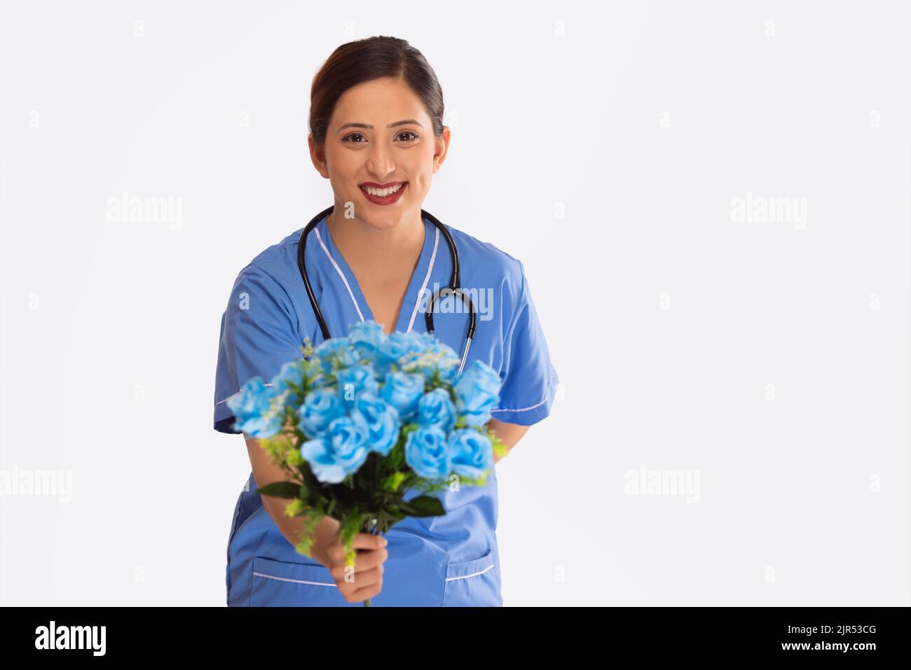 Portrait of smiling female nurse giving flower bouquet to patient Stock ...