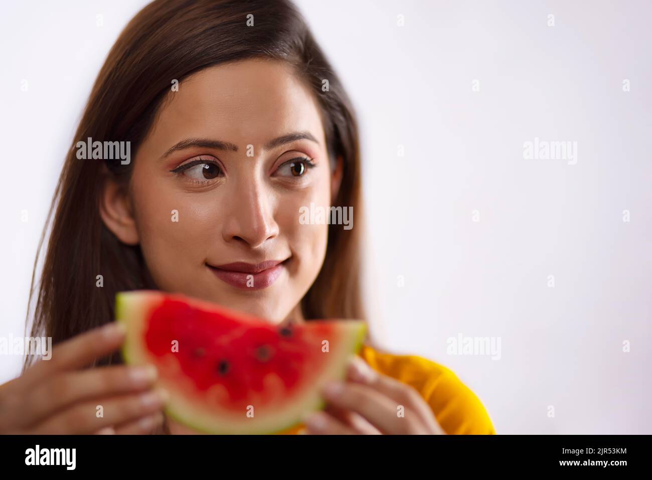 Young woman holding watermelon against white background Stock Photo - Alamy